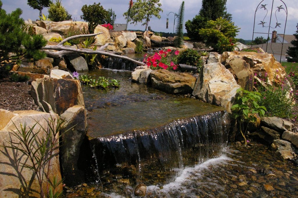 Multi-Tier Water Feature with Large Boulders and Vibrant Plantings